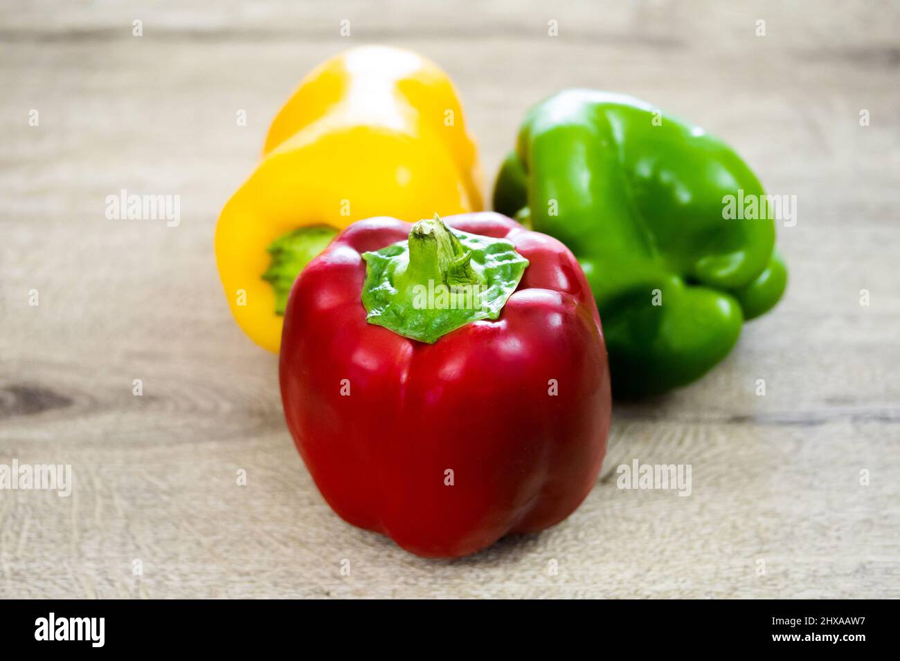 tricolor pepper on a wooden background Stock Photo - Alamy
