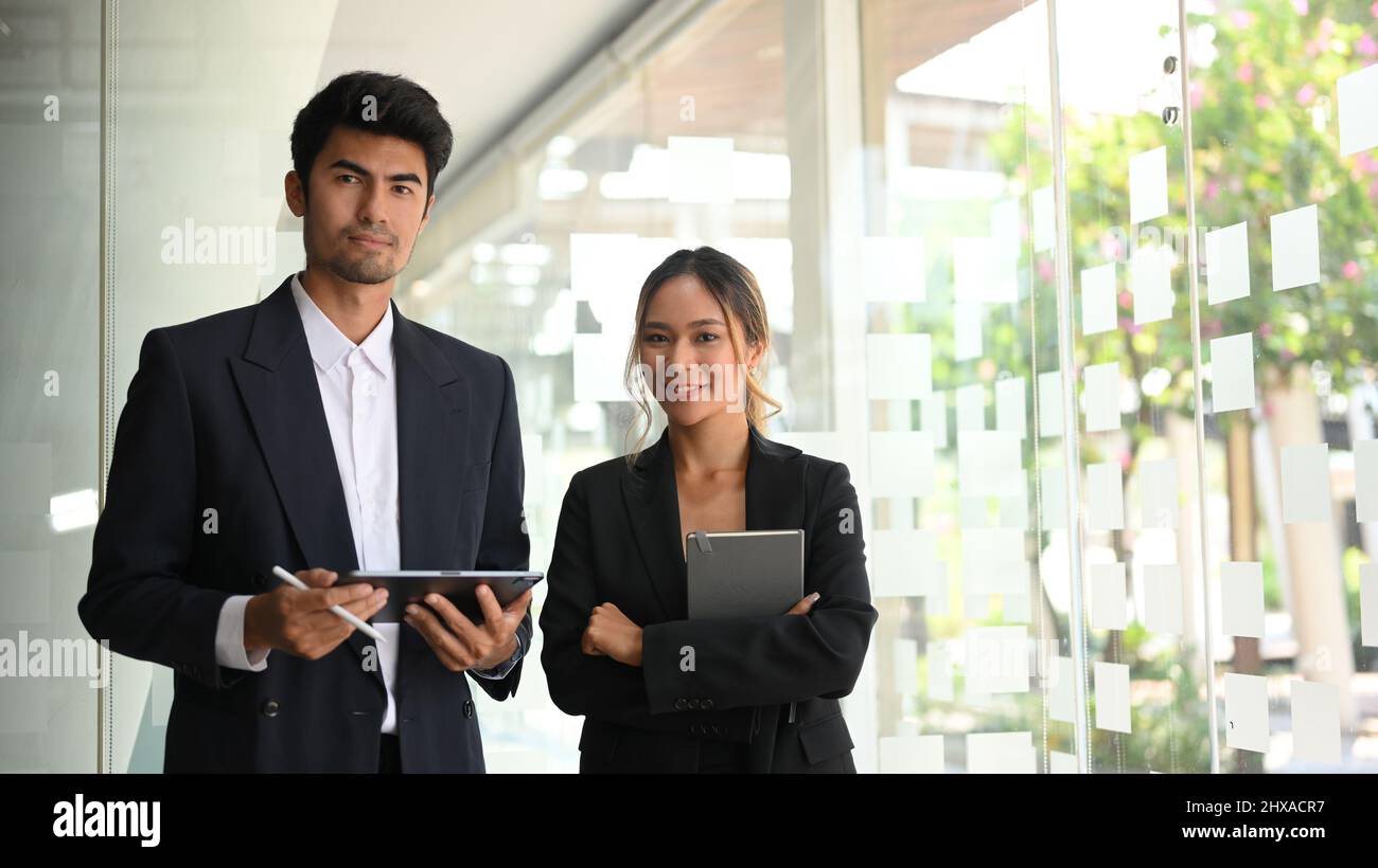 Portrait of two Asian business workers in formal suit with digital ...