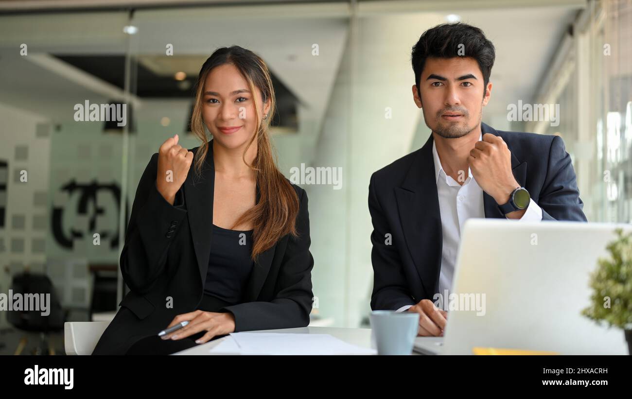 Two businesspeople in the office with hand rise, empower, successful ...