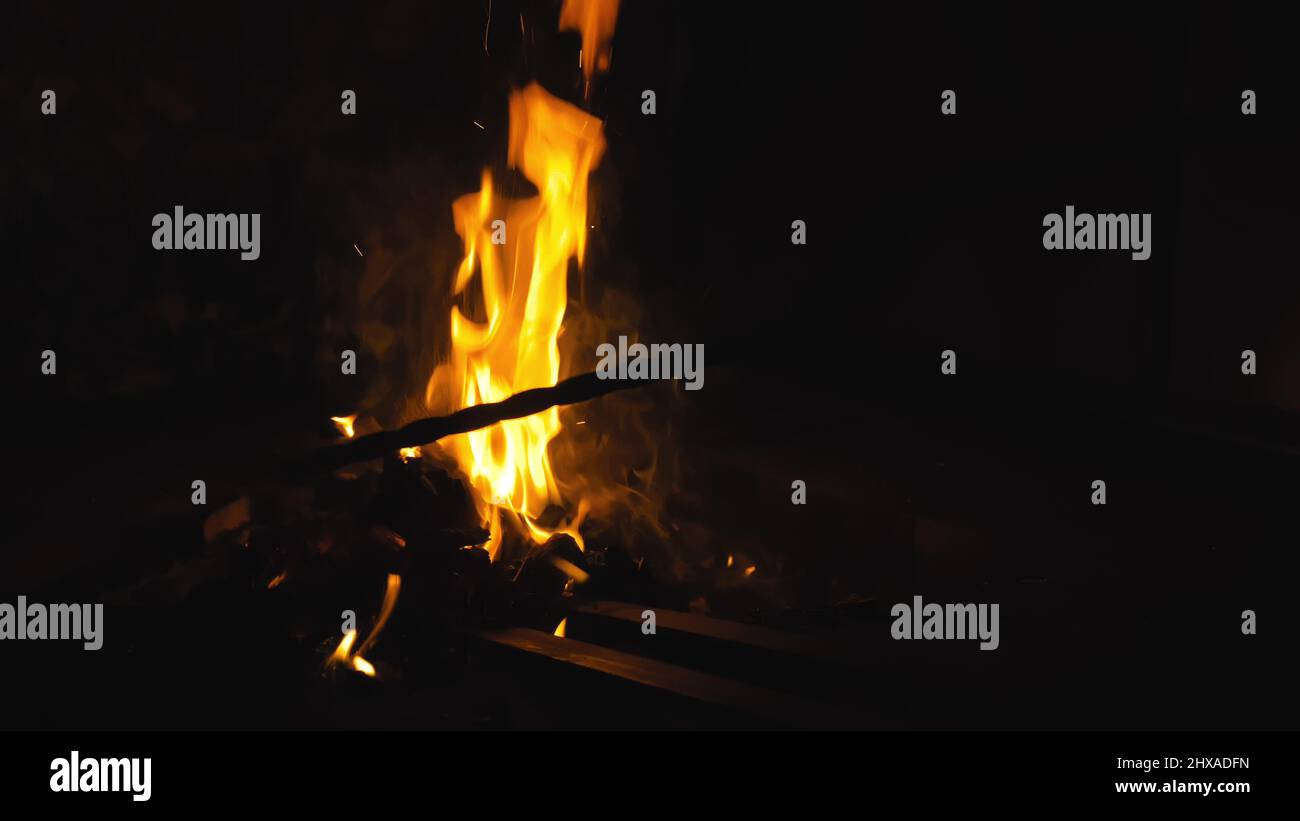 Forge fire in furnace. Blacksmith tempers a steel product in a stove ...