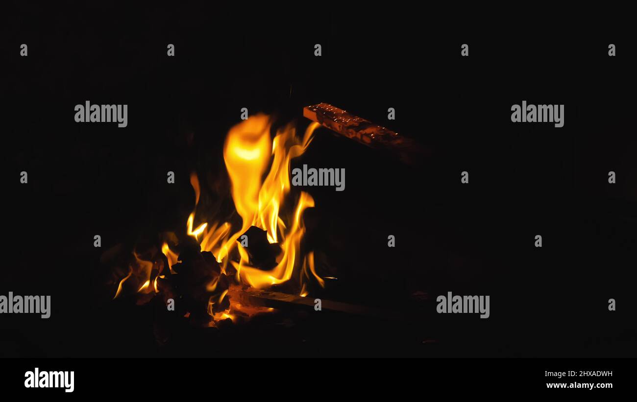 Forge fire in furnace. Blacksmith tempers a steel product in a stove ...