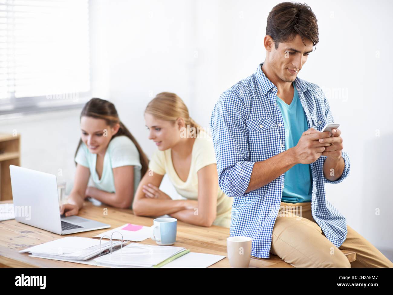 Taking a break for a while. A handsome young man typing on his phone ...