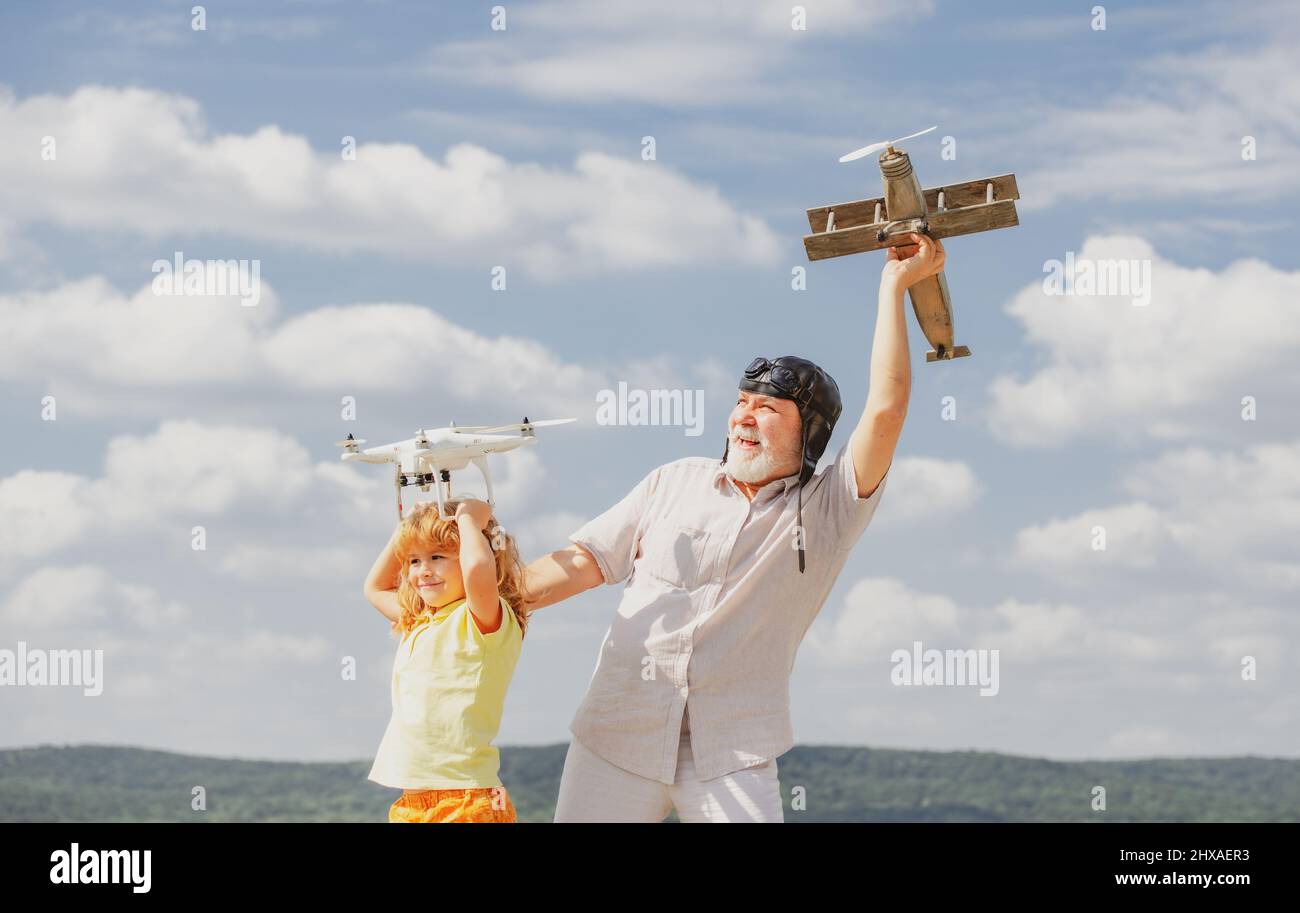 Young grandson and old grandfather with plane and quadcopter drone over ...