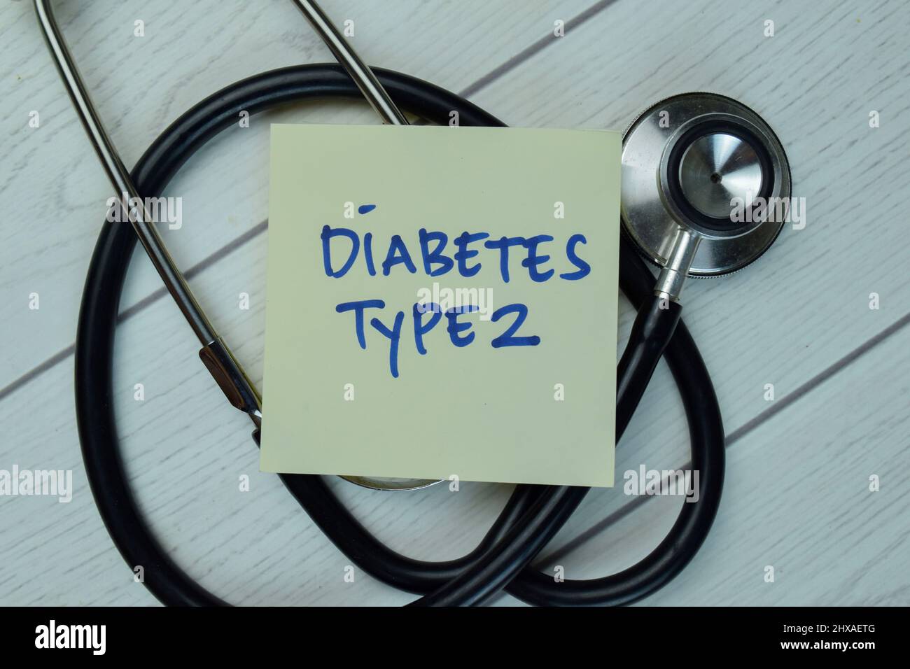 Diabetes Type 2 write on sticky notes isolated on Wooden Table. Medical ...