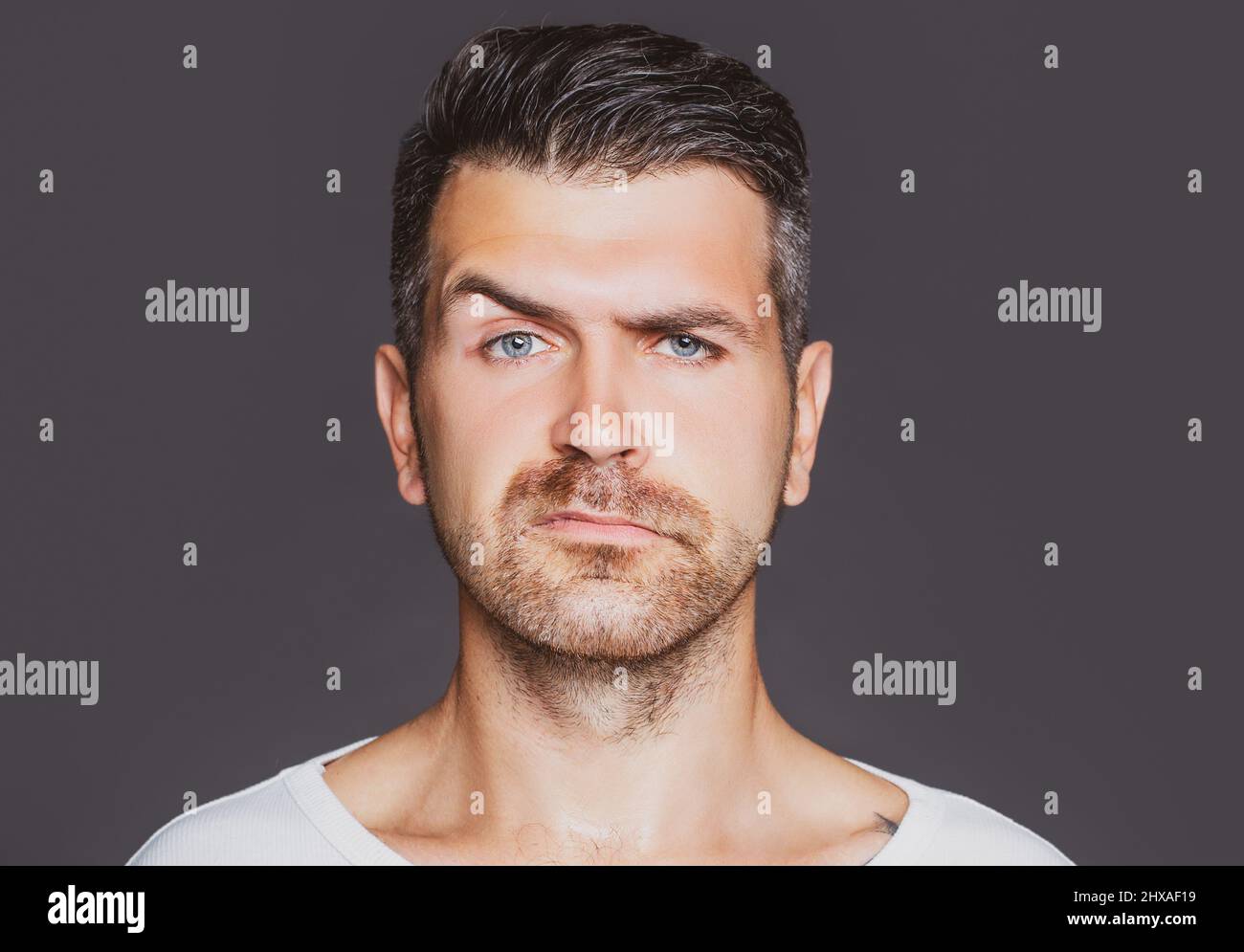Closeup portrait of handsome shaved man with bristle and eyebrow raised ...