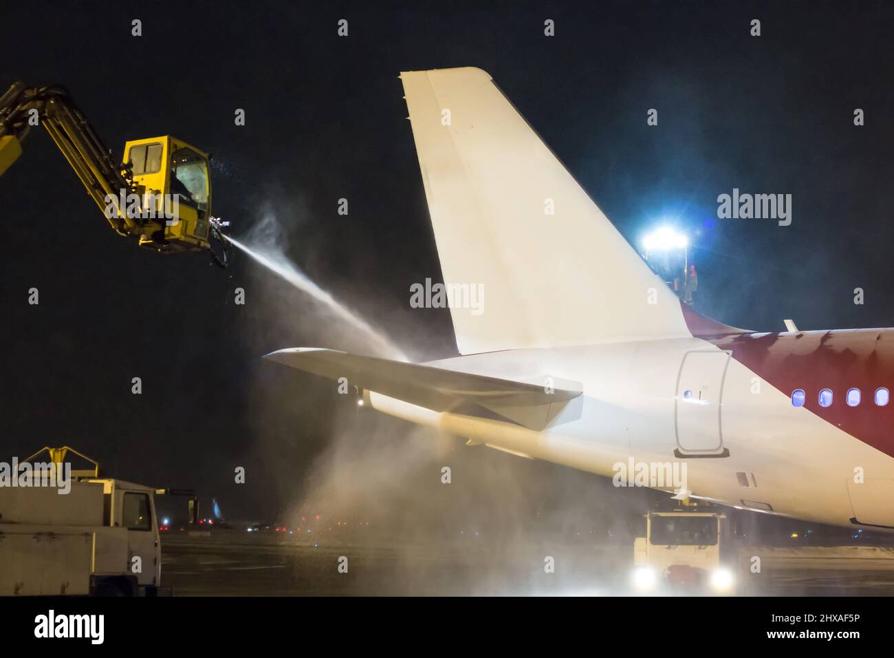 Ground deicing of the tail section of a passenger aircraft at night ...