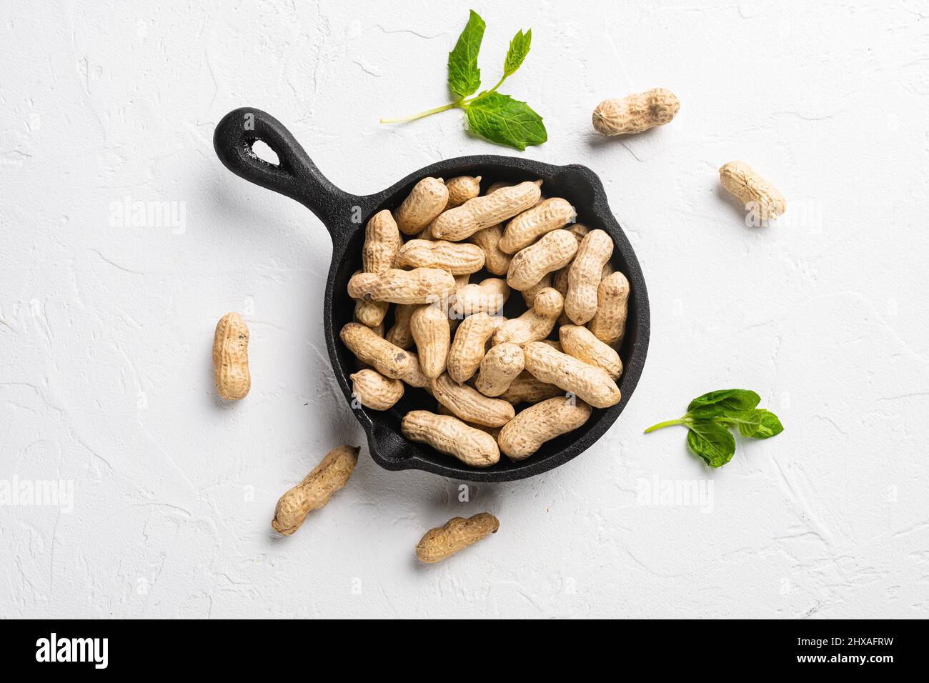 Organic peanuts in shell set, on white stone table background, top view ...