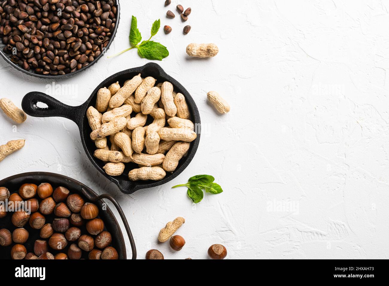 Organic peanuts in shell set, on white stone table background, top view ...