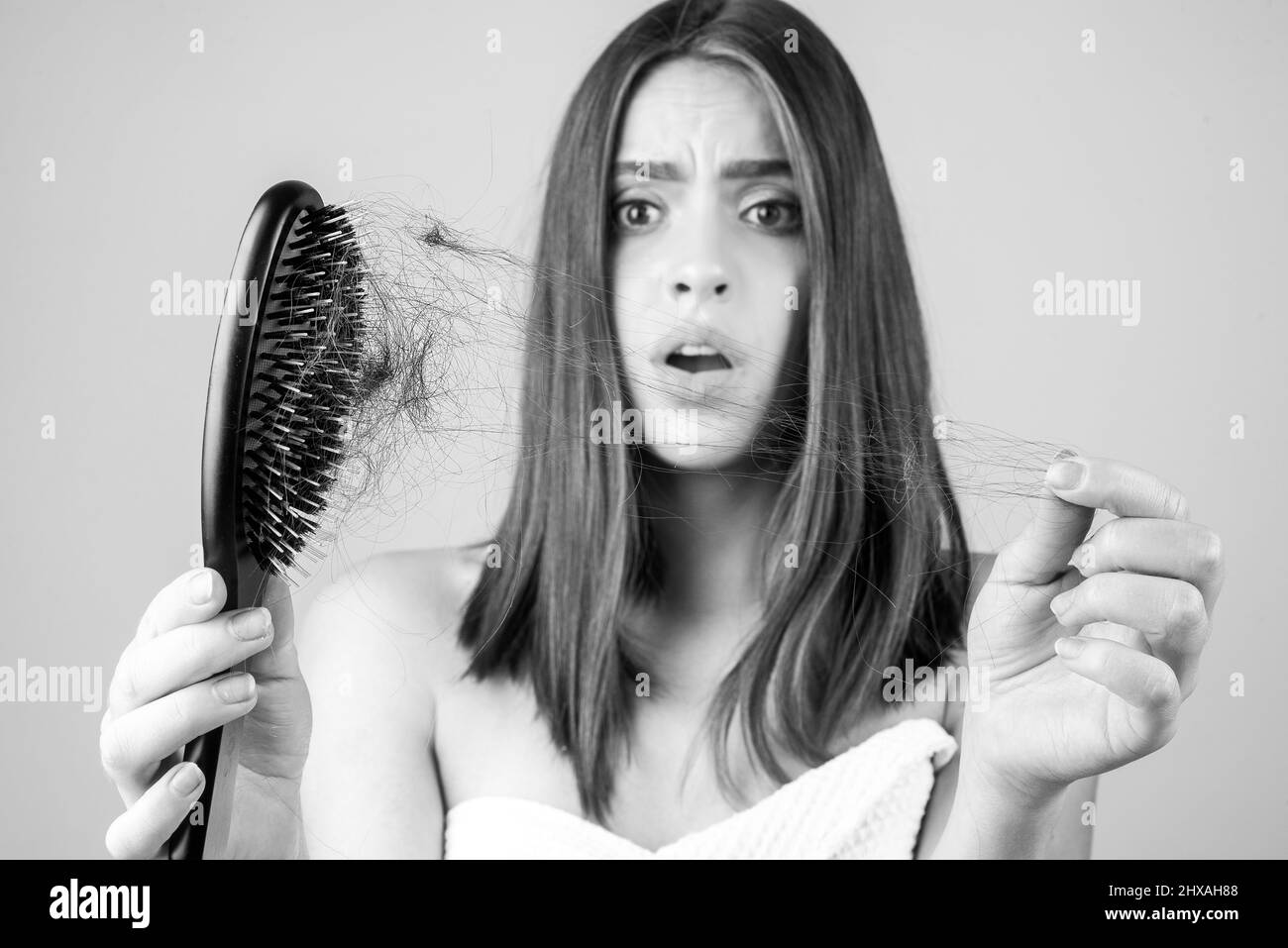 Sad girl looking at damaged hair, the hair loss problem. Isolated, copy ...