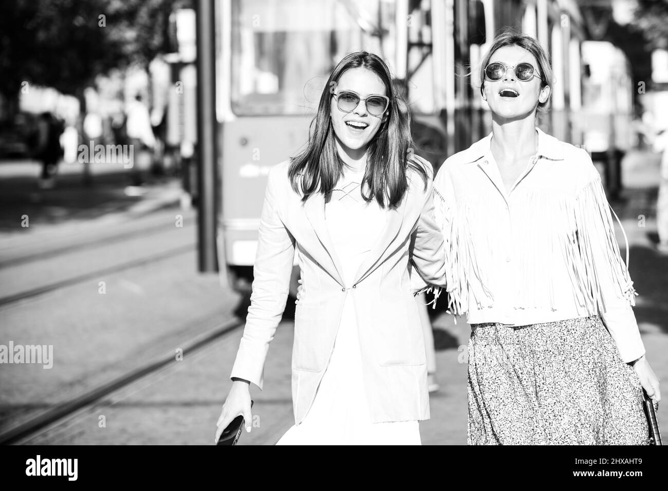Girls with expressing positive emotions walking on the city street ...