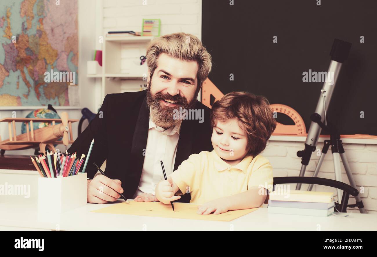 Cute little preschool kid boy with teacher study in a classroom ...