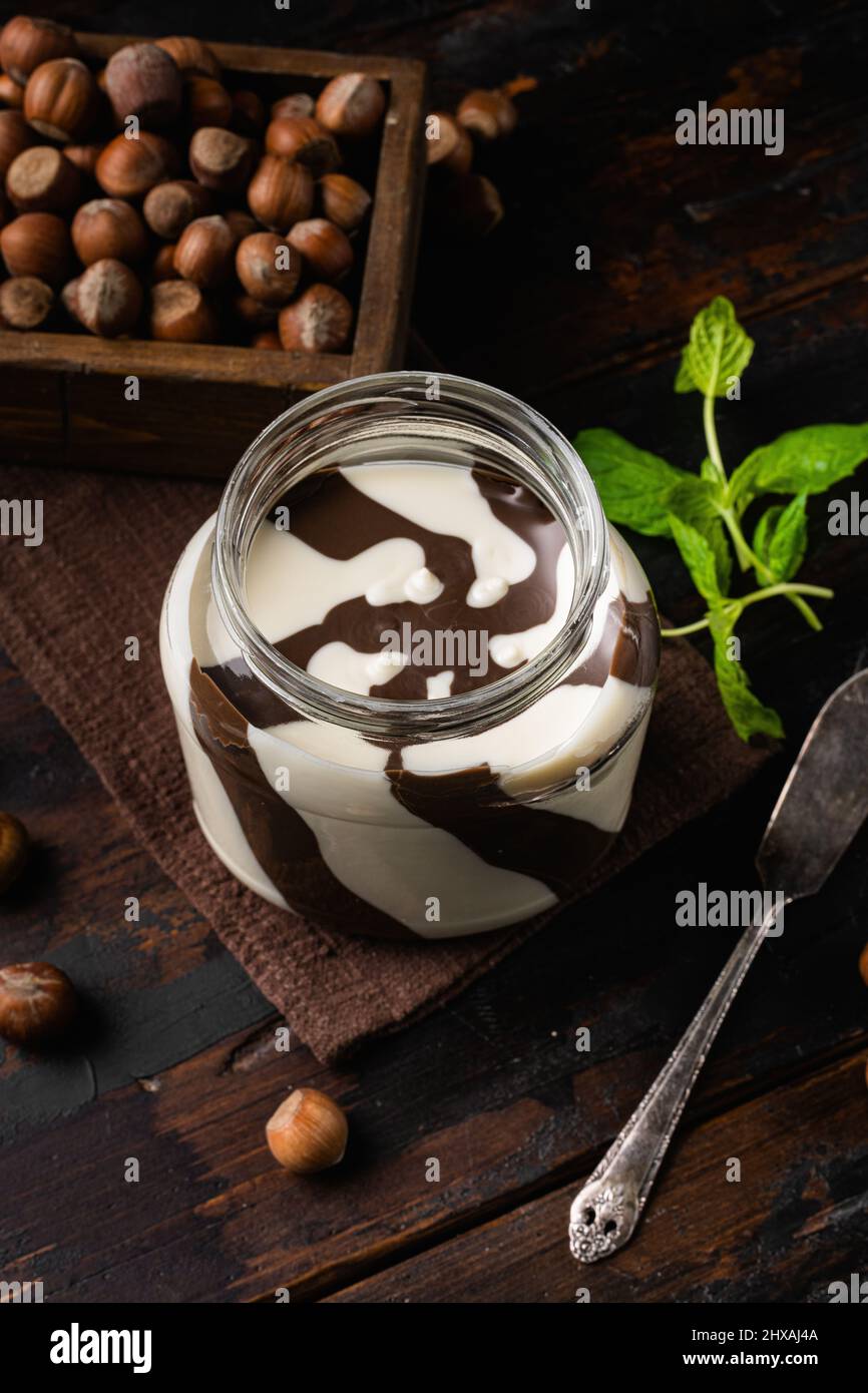 Chocolate hazelnut in jar with nuts set, on old dark wooden table ...