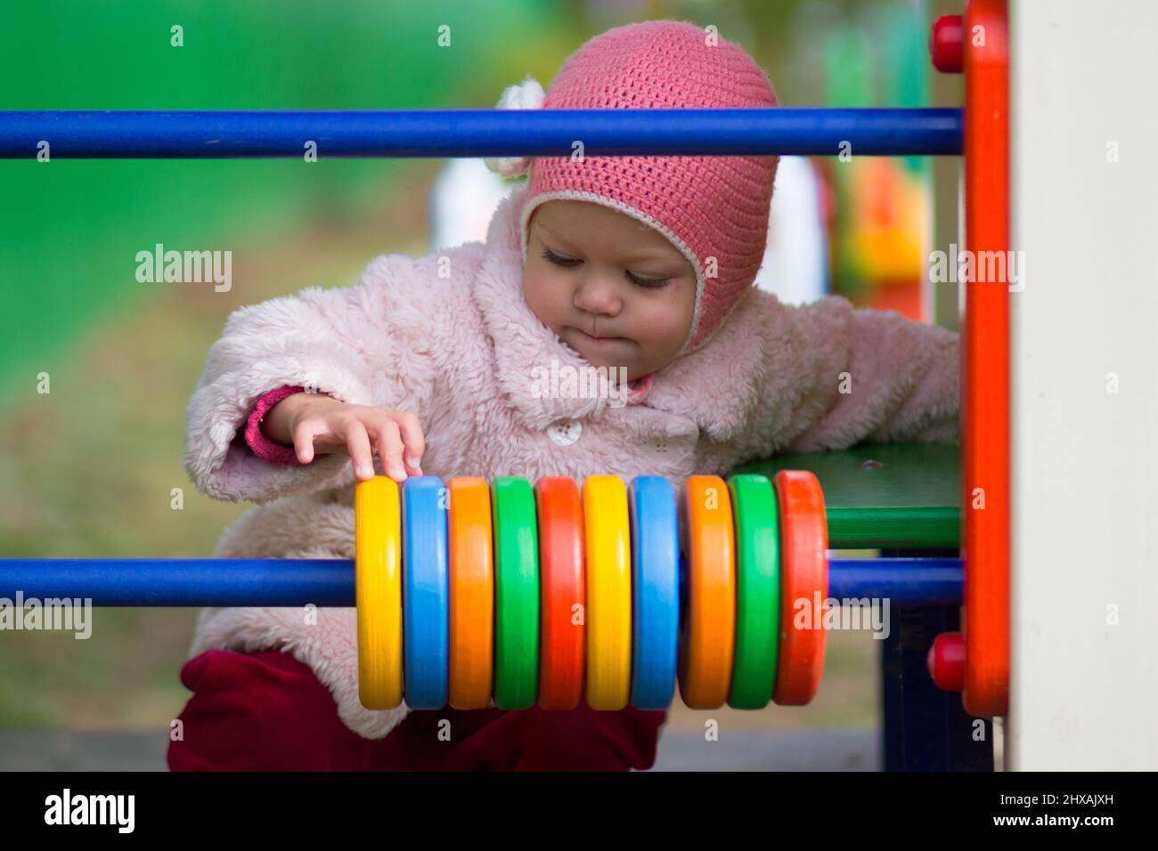 Little girl playing with the wooden toy counter outside Stock Photo - Alamy
