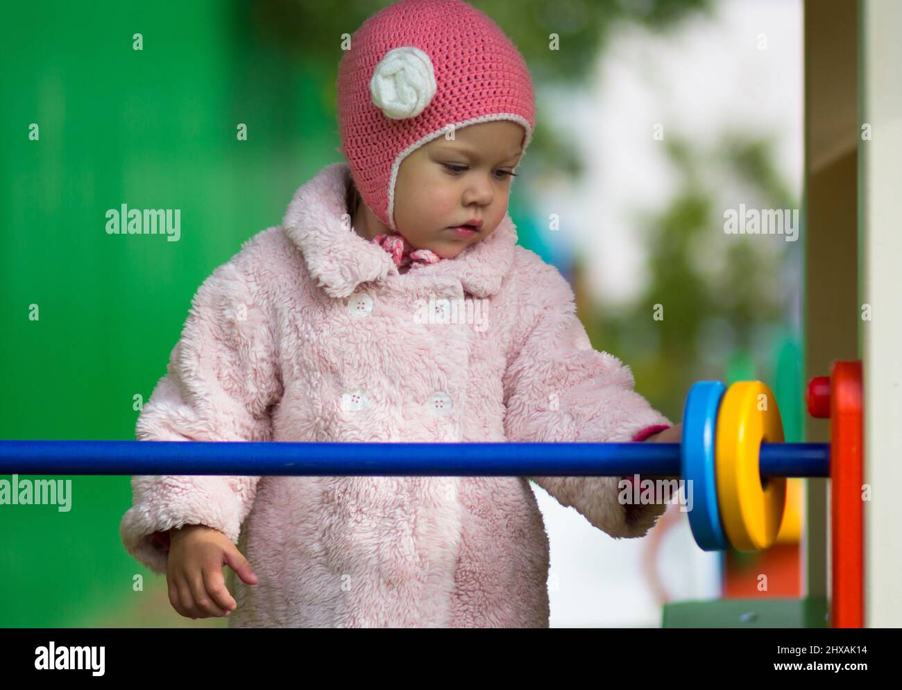 Little girl playing with the wooden toy counter outside Stock Photo - Alamy