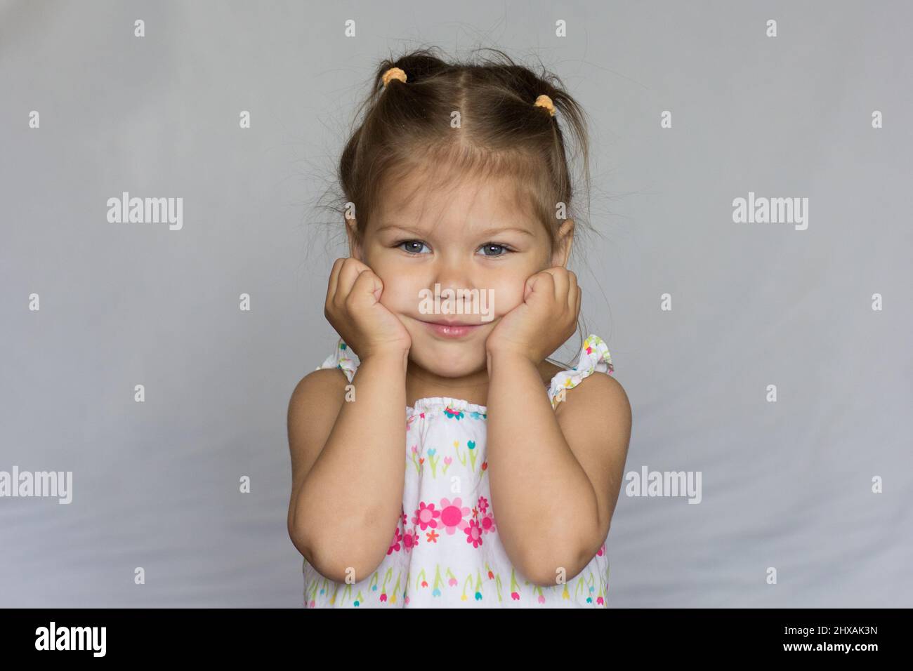 Happy child holding her cheeks by hands on the white background Stock ...