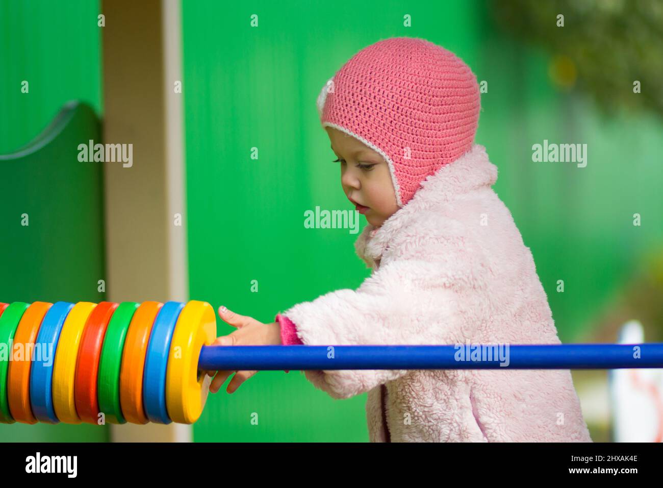Little girl playing with the wooden toy counter outside Stock Photo - Alamy