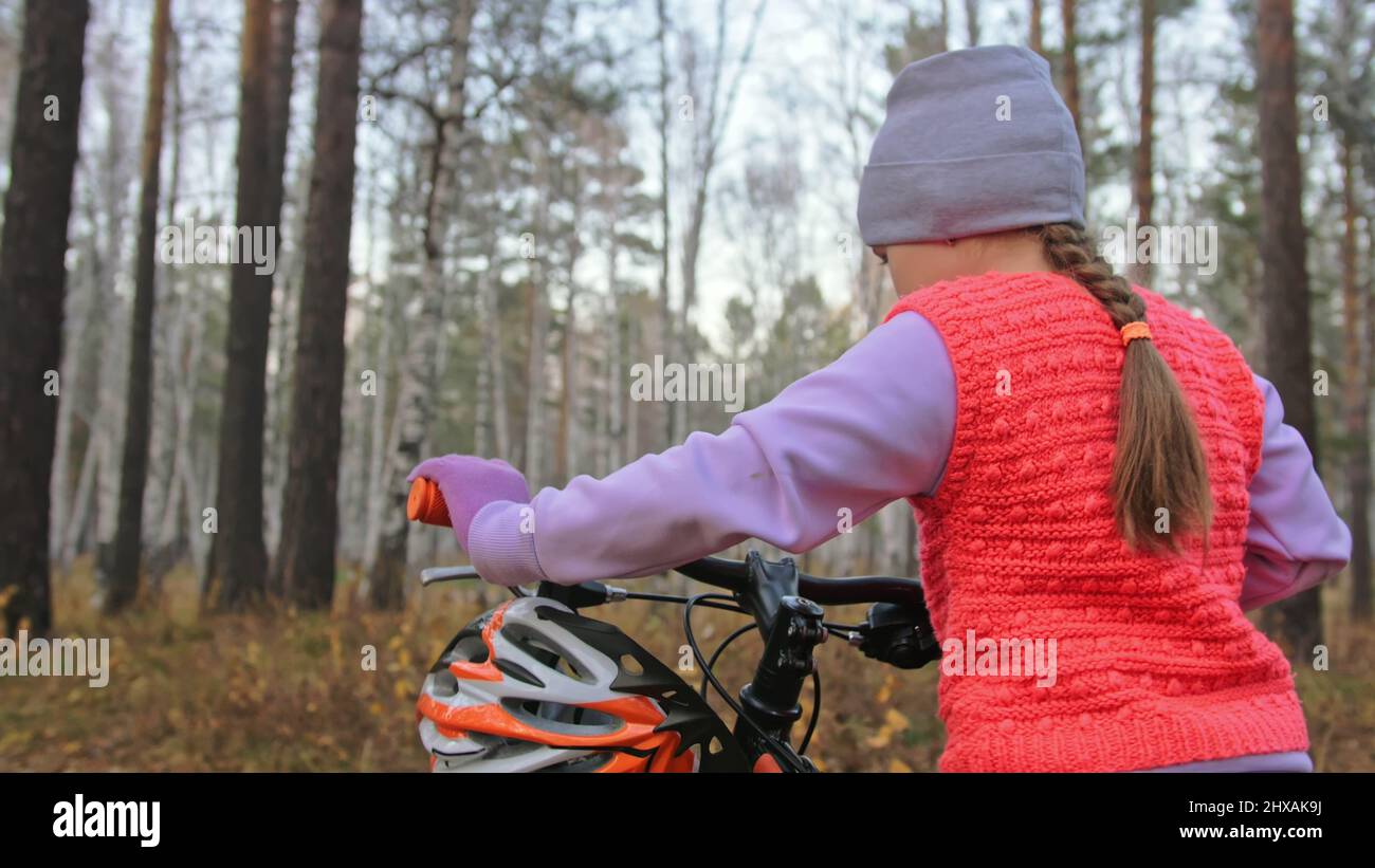 One caucasian children walk with bike in autumn park. Little girl ...