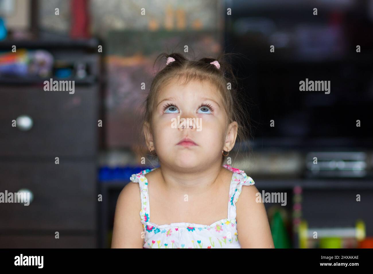 Portrait of cute and funny little girl raising eyes up Stock Photo - Alamy