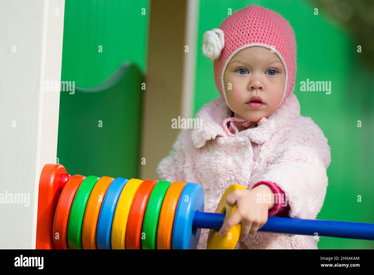 Little girl playing with the wooden toy counter outside Stock Photo - Alamy
