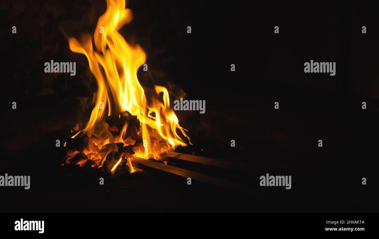 Forge fire in furnace. Blacksmith tempers a steel product in a stove ...