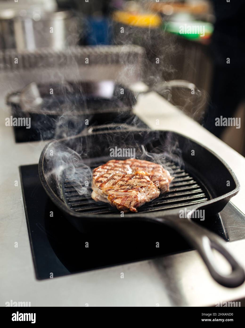 Cooking beef steak on grilling pan in the kitchen Stock Photo - Alamy