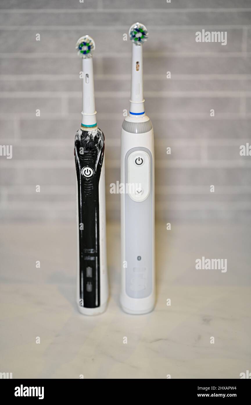 unclean electric toothbrush standing on bench in bathroom Stock Photo ...