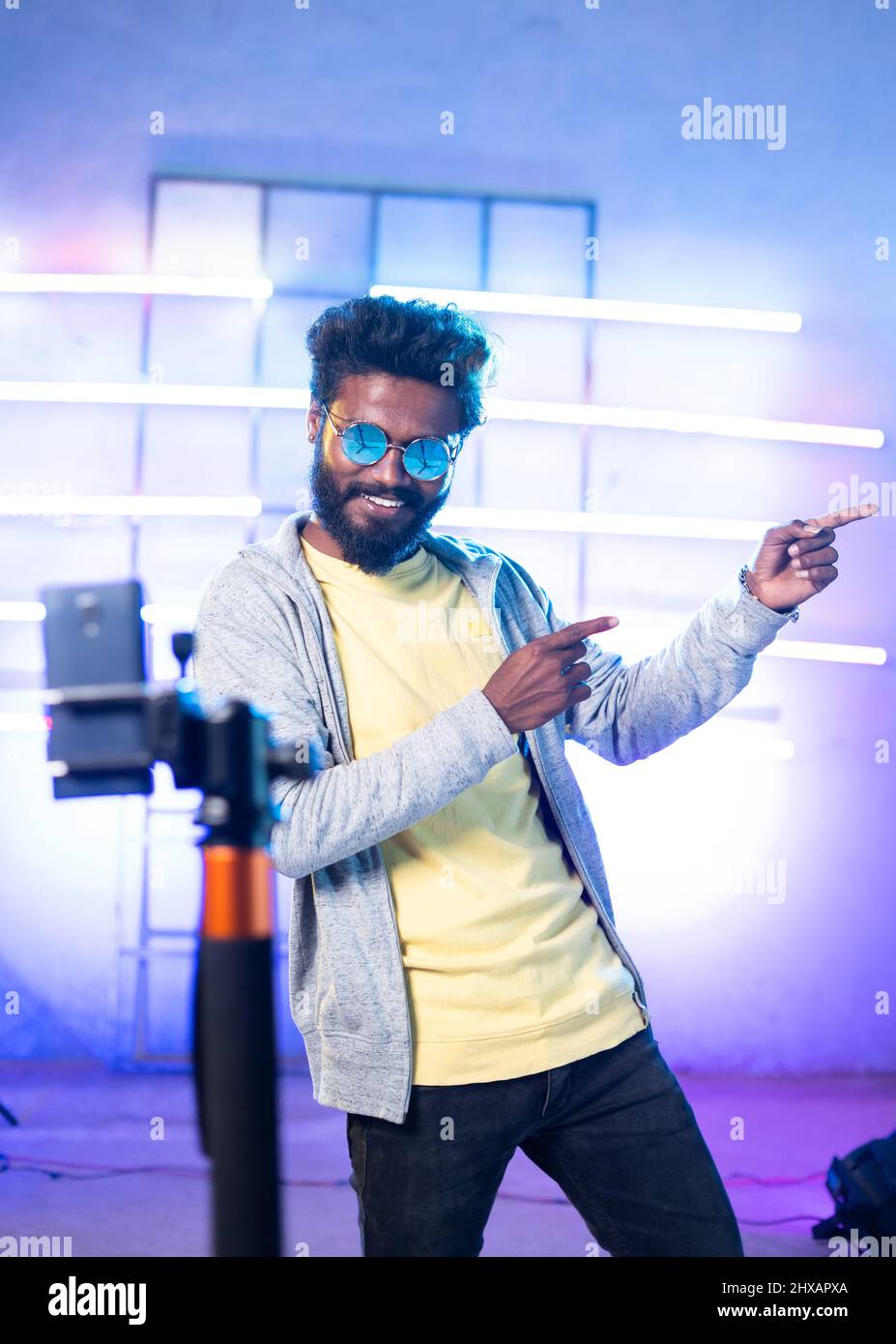 young man recording dancing video on mobile phone during stage ...