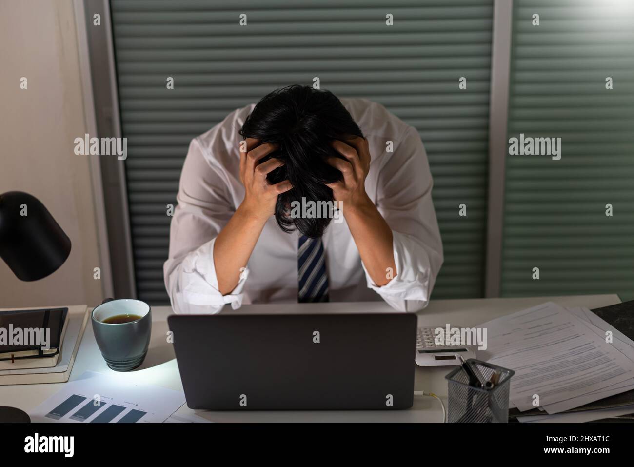 Overwork Concept The male who works at the office tonight holding his ...