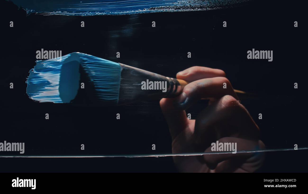 The artist draw on glass. Back view. Craftsman decorator use large ...