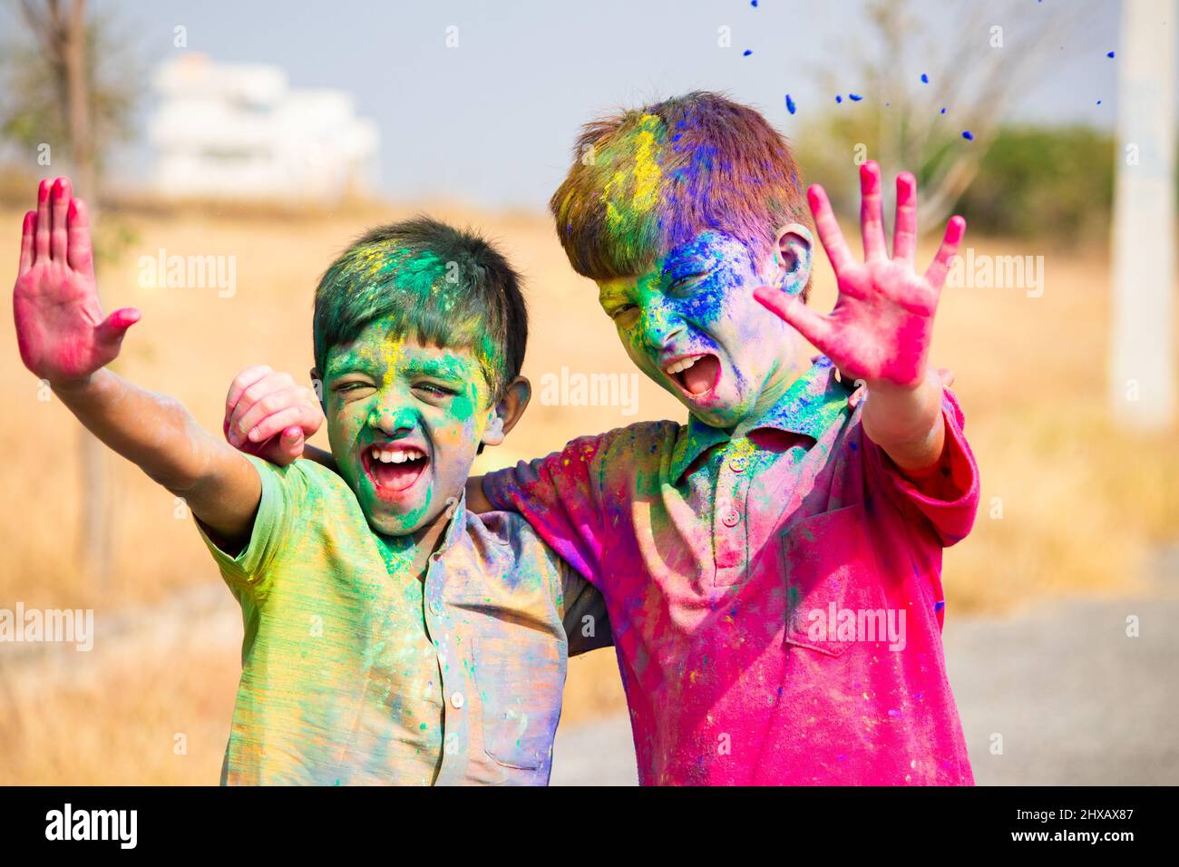 cheerful two Indian kids shouting by looking at camera after playing ...