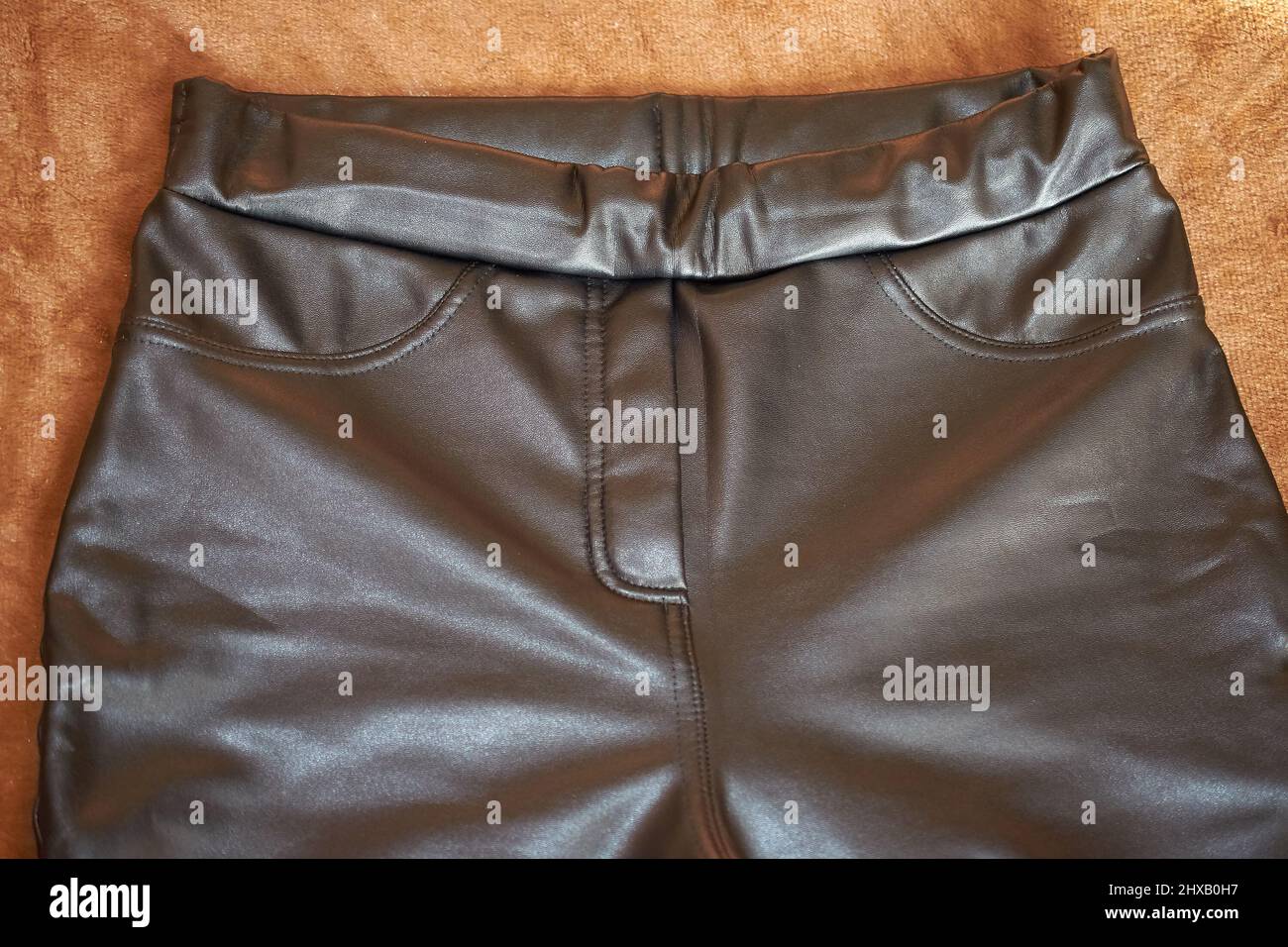 Upper part of black leather pants, front view Stock Photo - Alamy
