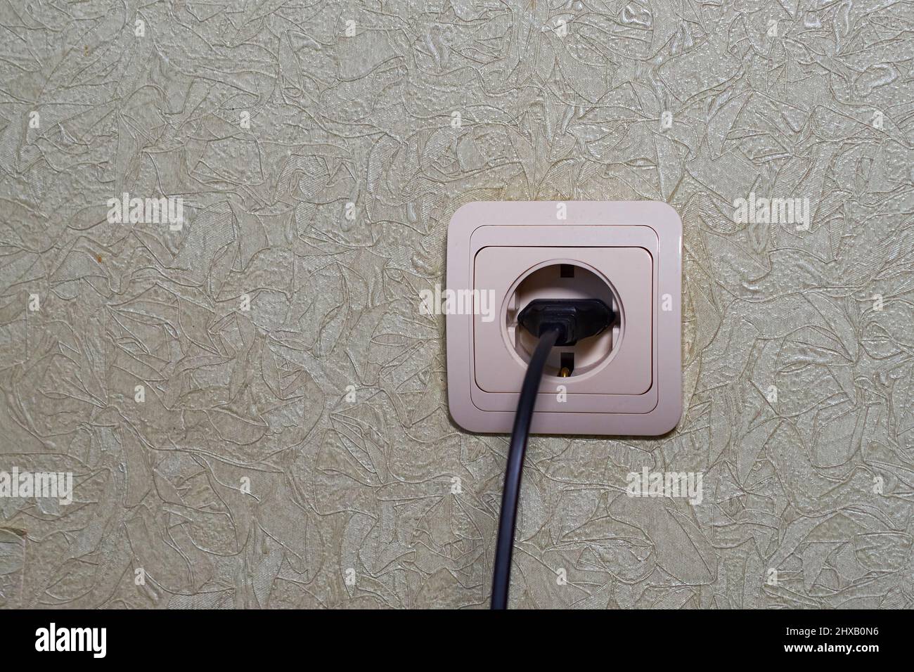 A wire with a plug from an electrical appliance is inserted into an ...