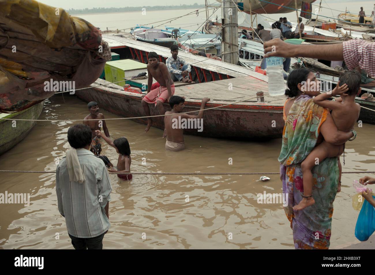 Pilgrims take a bath ritual, as the others are standing on the side of ...