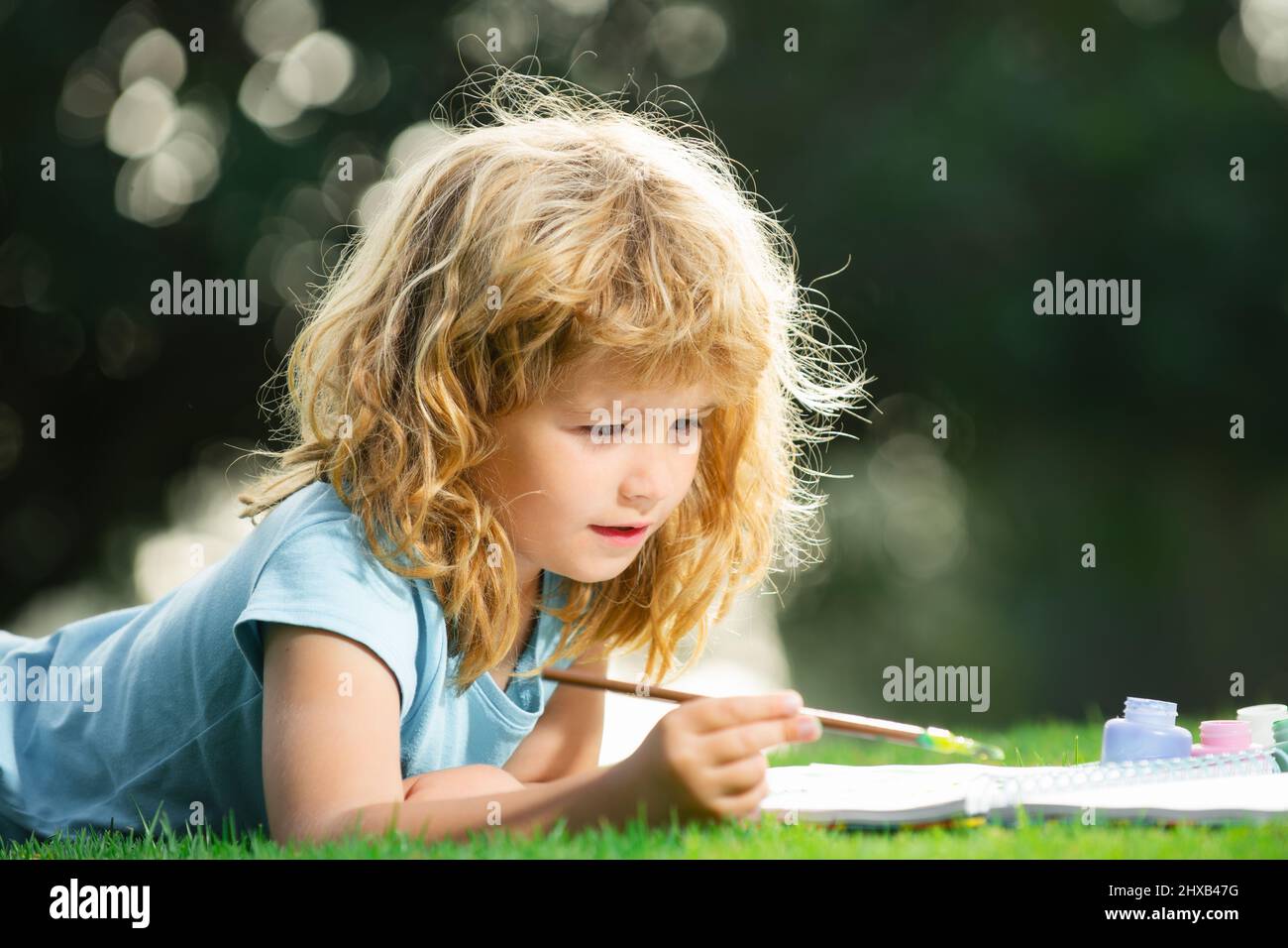 Child boy drawing in summer park, painting art. Little artist painter ...