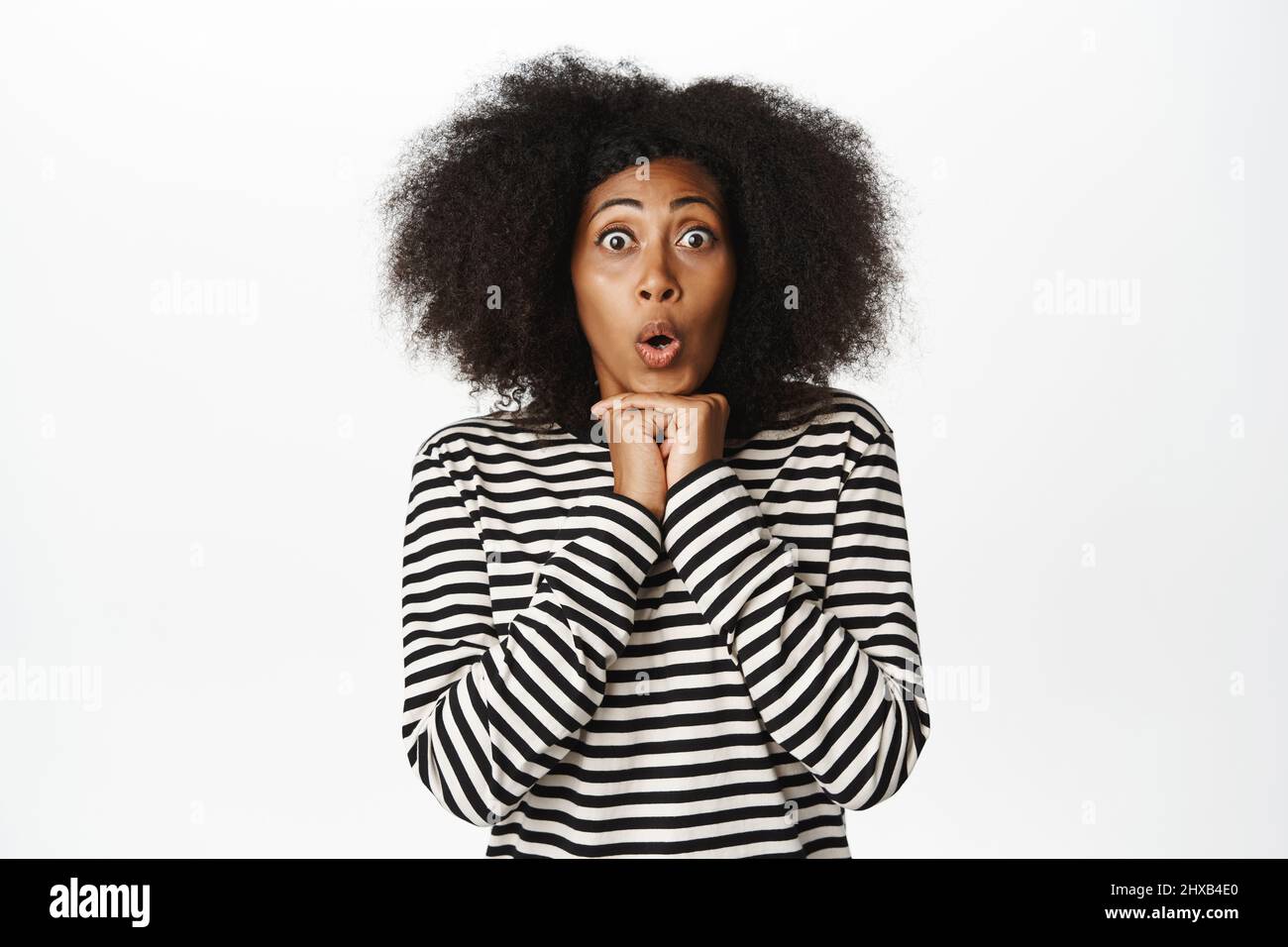 Image of excited african american woman looking with amazement, staring ...