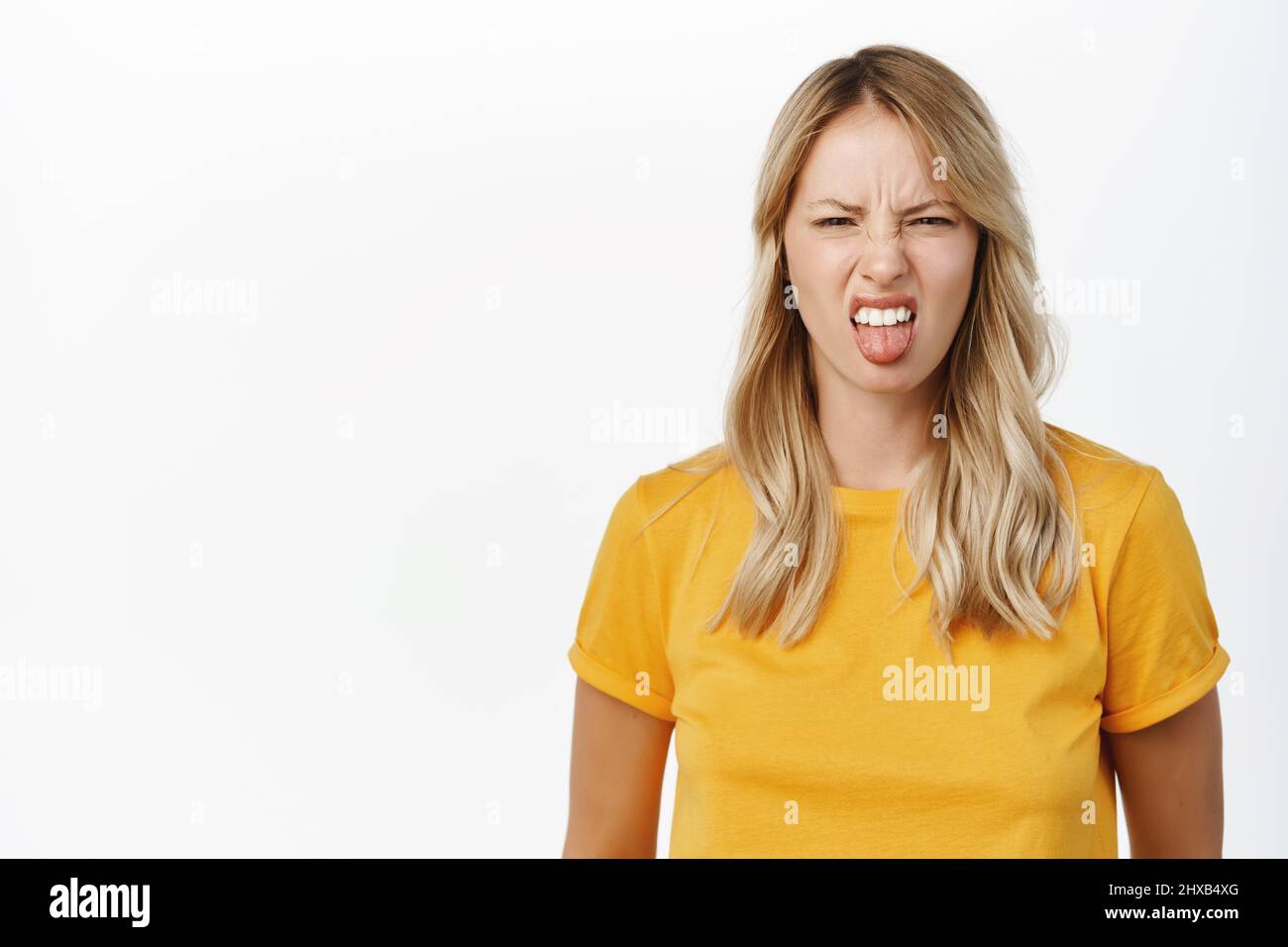 Dislike and aversion. Young woman grimaces and look with disgust at ...