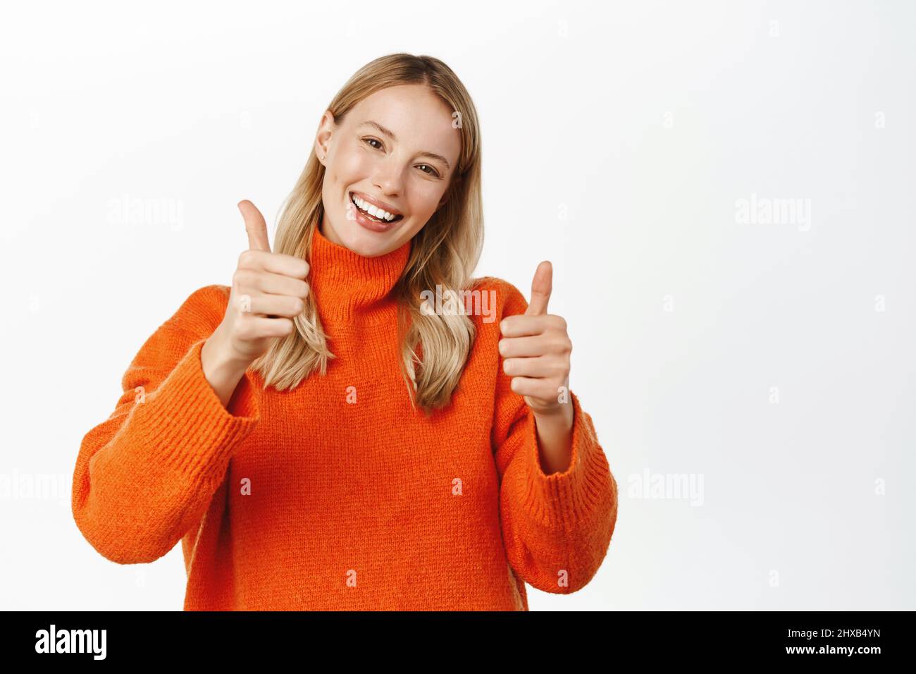 Portrait of smiling blond attractive woman, showing thumbs up in ...