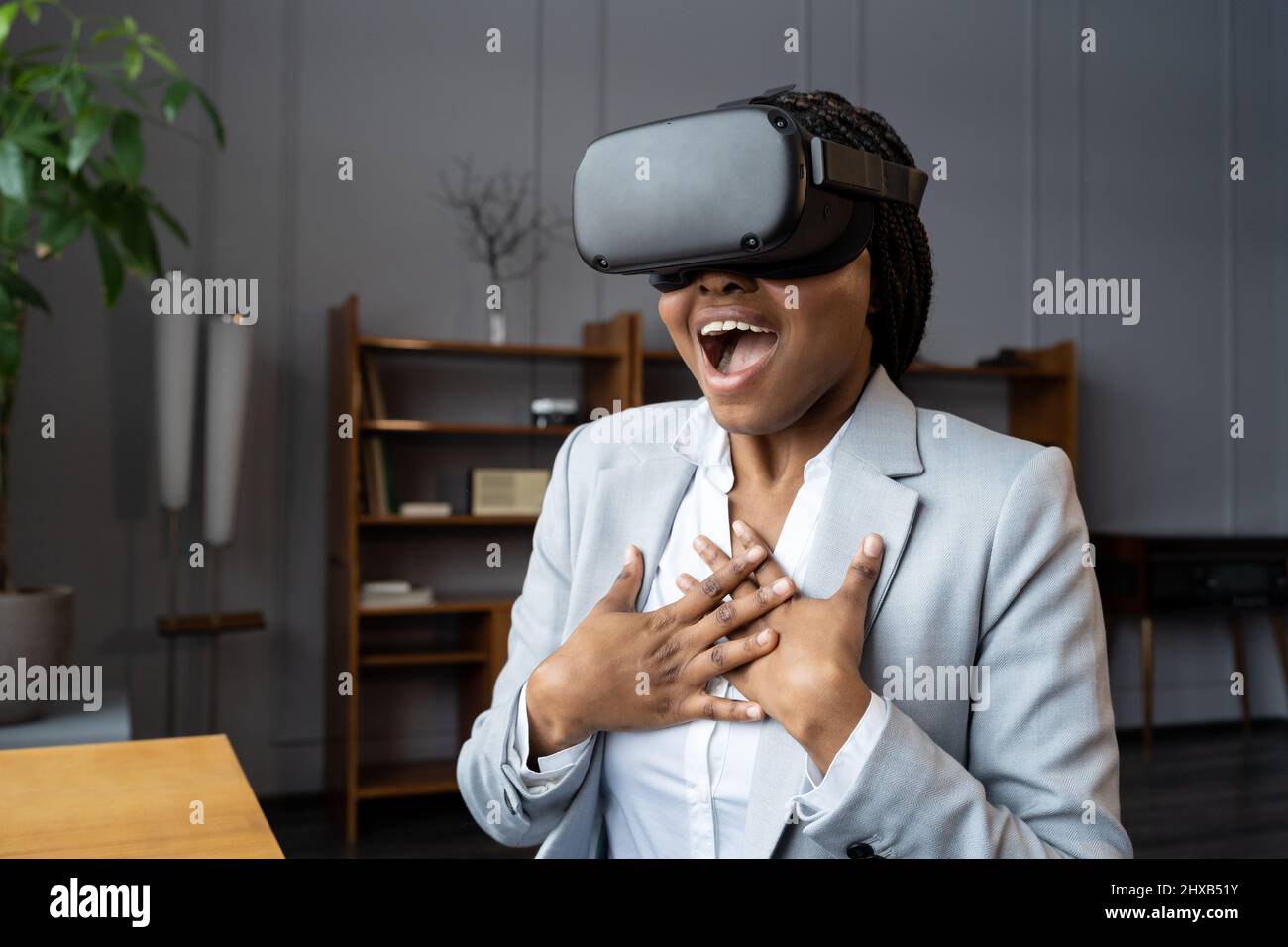 Emotional shocked african businesswoman in VR headset immersed in 3D ...