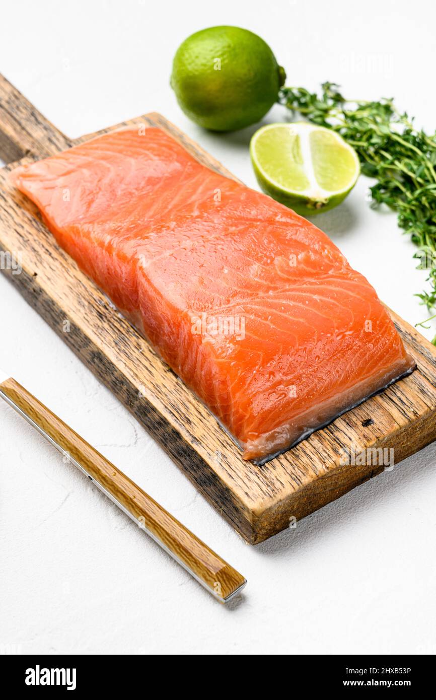 Fresh raw salmon fillet set, with herbs, on white stone table ...