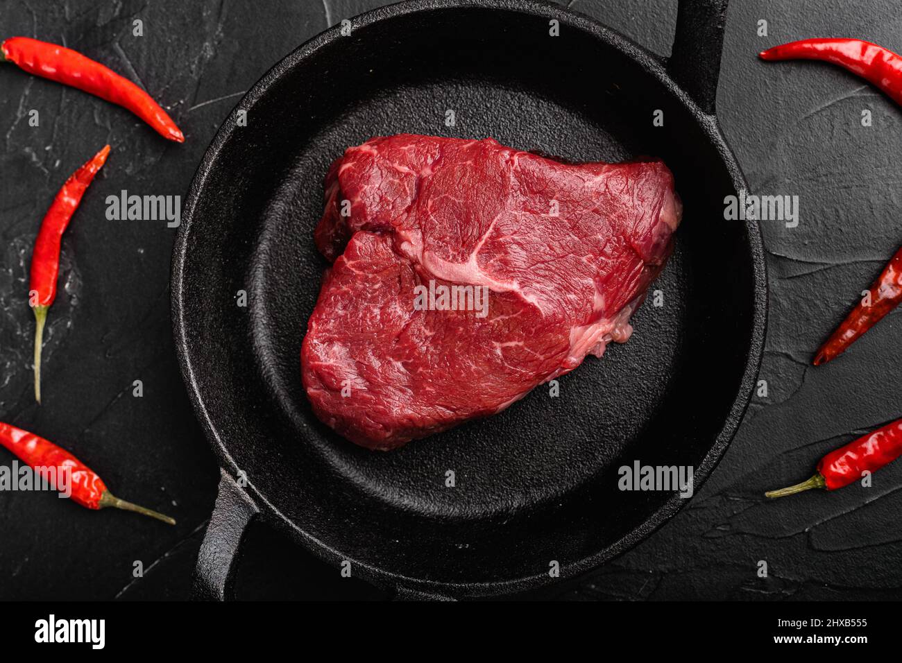 Raw cap rump steak set, on black dark stone table background, top view ...