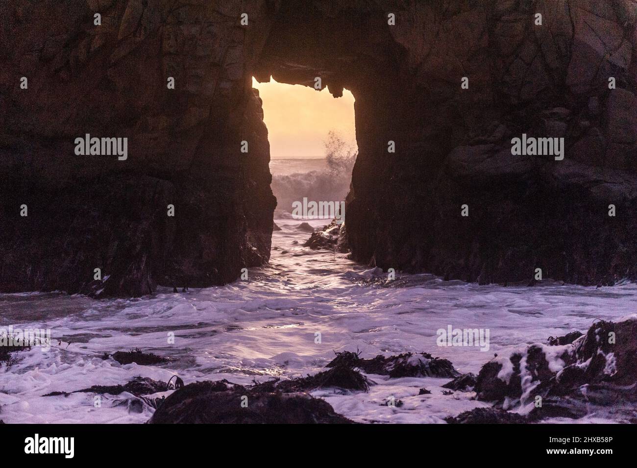 A sunset sky peeping thought the keyhole arch at Pfeiffer Beach, near ...