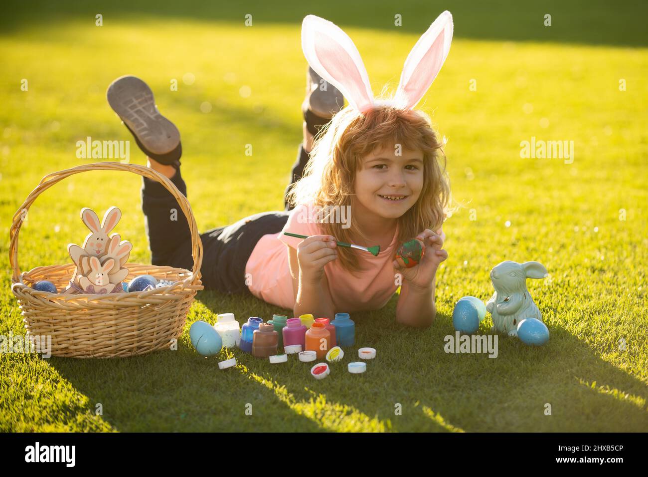 Easter bunny kids painting easter eggs. Child boy in bunny Easter ears ...