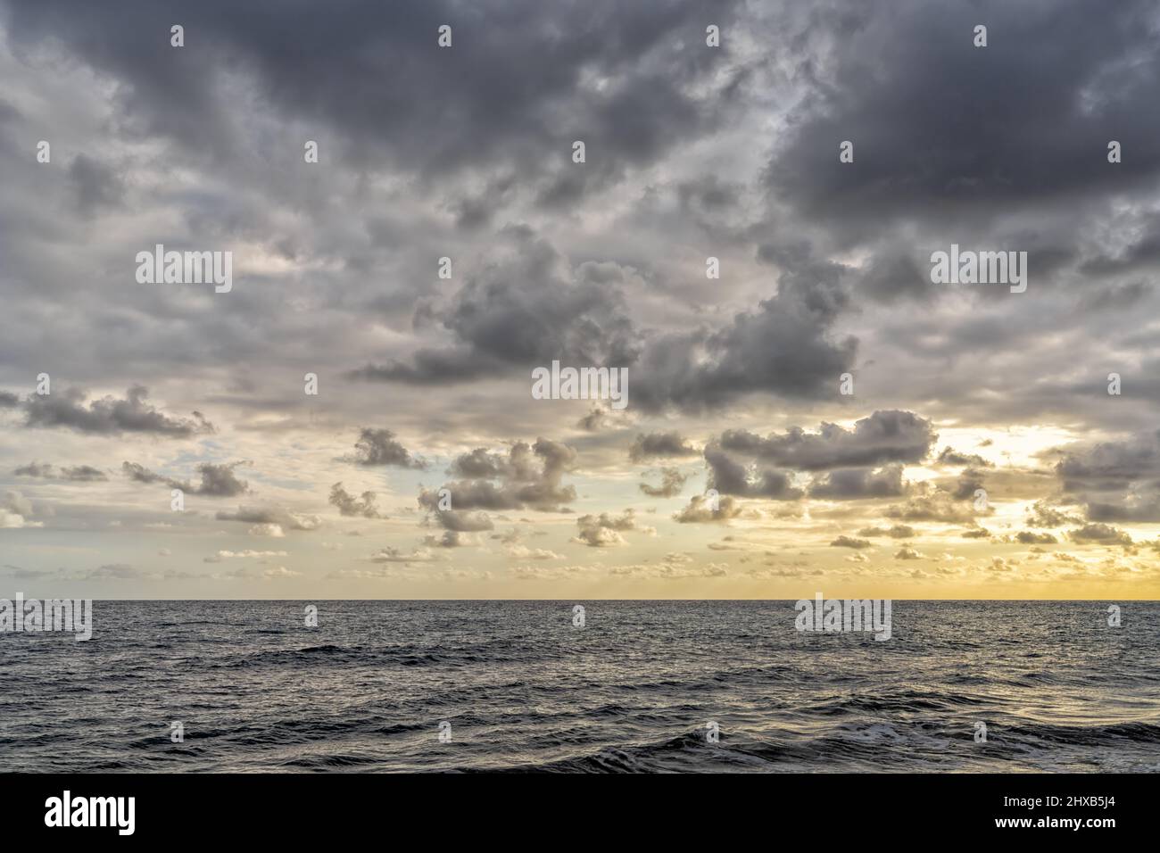 A horizontal landscape view of a backdrop of calm ocean water under an ...