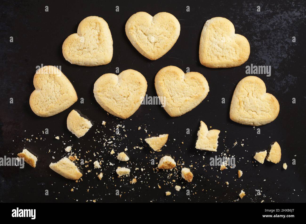 Cookies in the shape of a heart whole end broken on old black metal ...