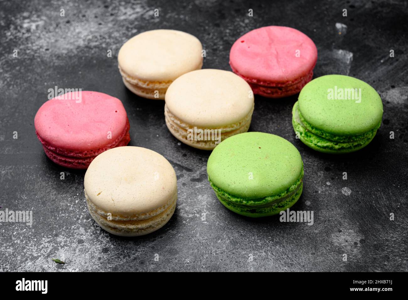 Colorful french macarons set, on black dark stone table background ...