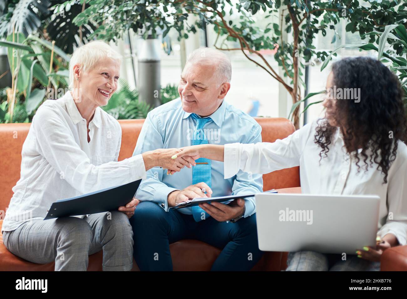 two business women shaking hands before starting a business discussion ...