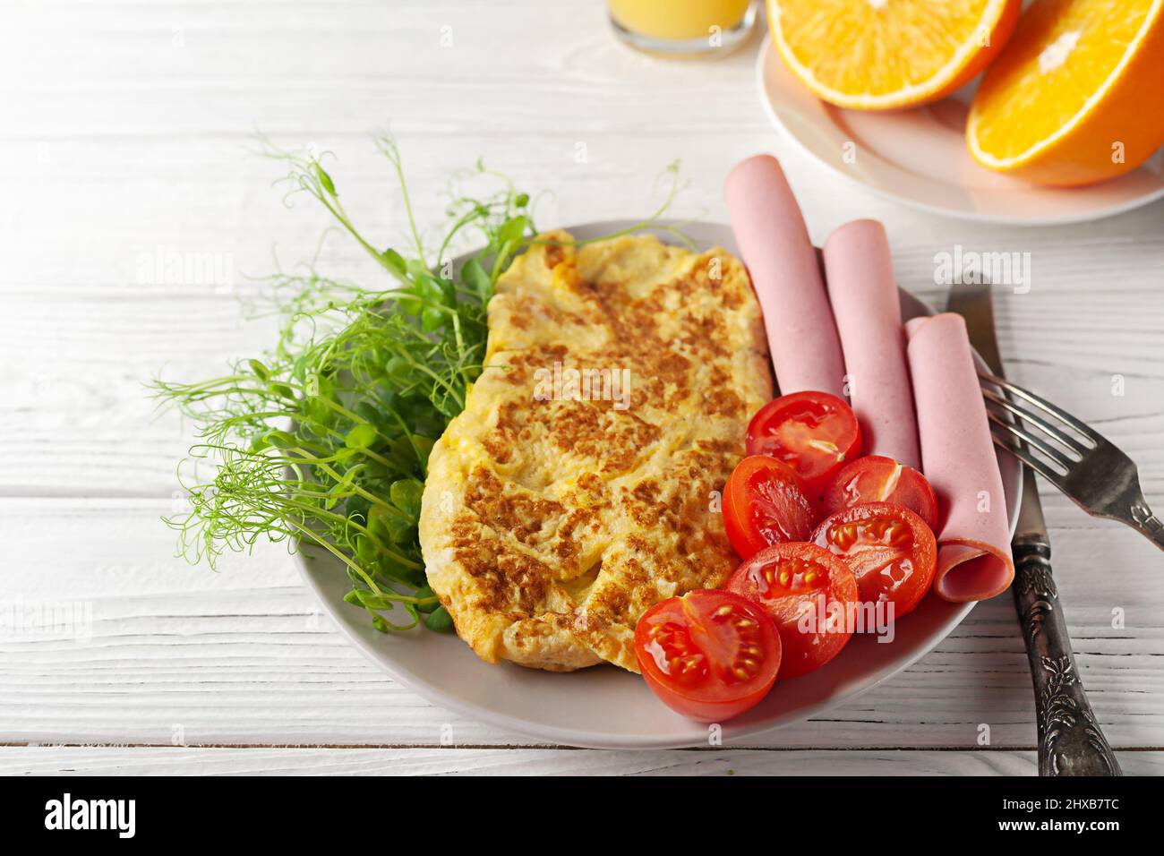 A light breakfast of French omelettes with sausage, tomatoes and ...