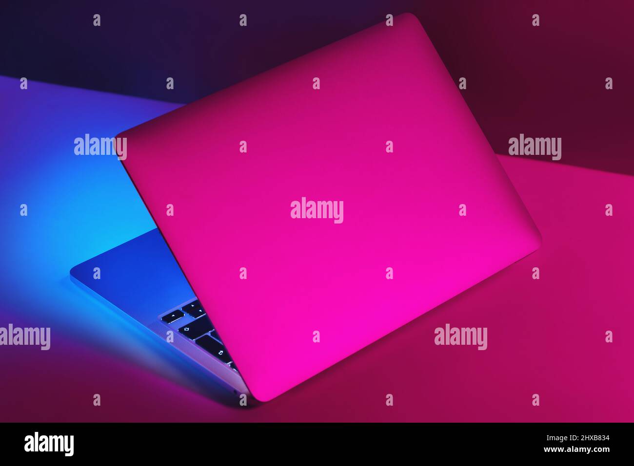 Creative version of an half opened laptop computer with purple and blue ...