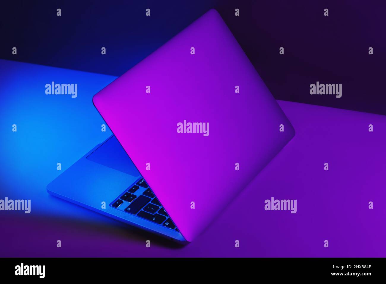 Creative version of an half opened laptop computer with purple and blue ...