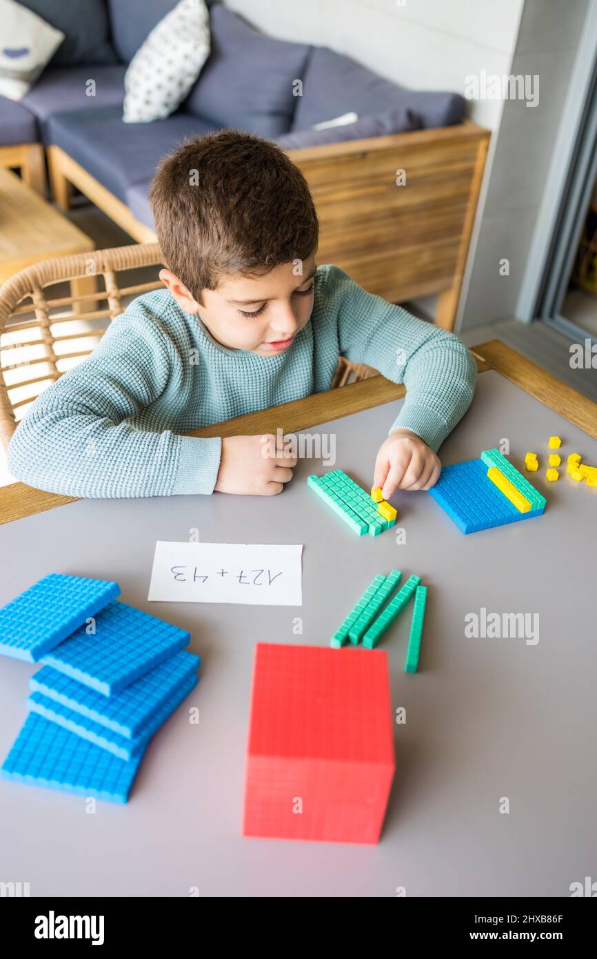 Little boy using the base 10 method to do addition at home Stock Photo ...